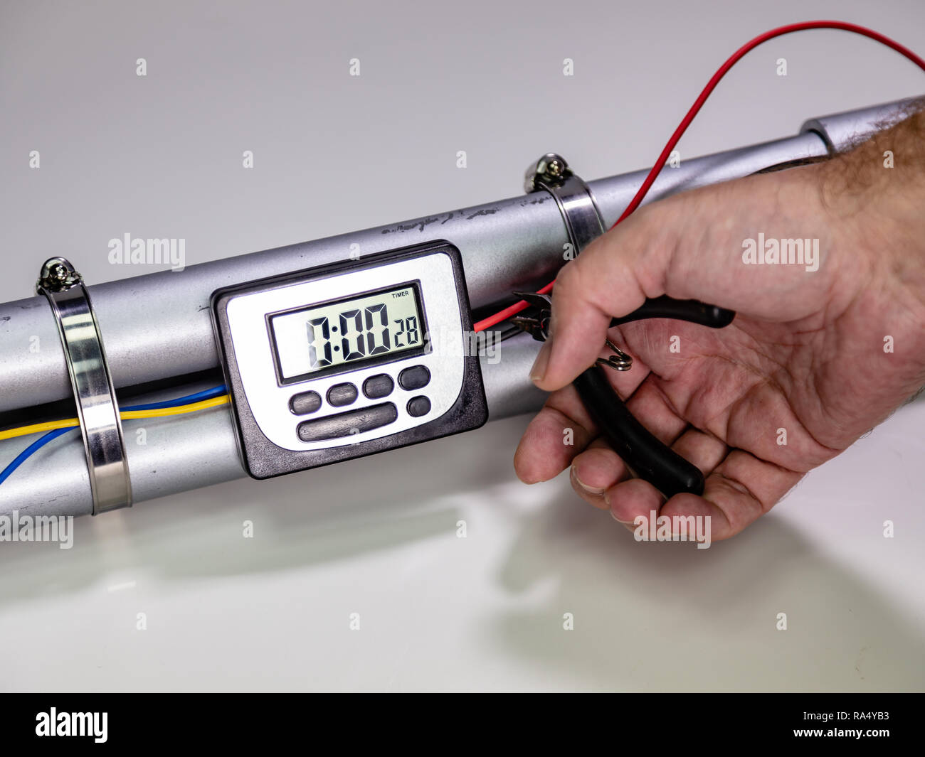 Hand cutting wire on pipe bomb with an lcd clock timer to trigger ...
