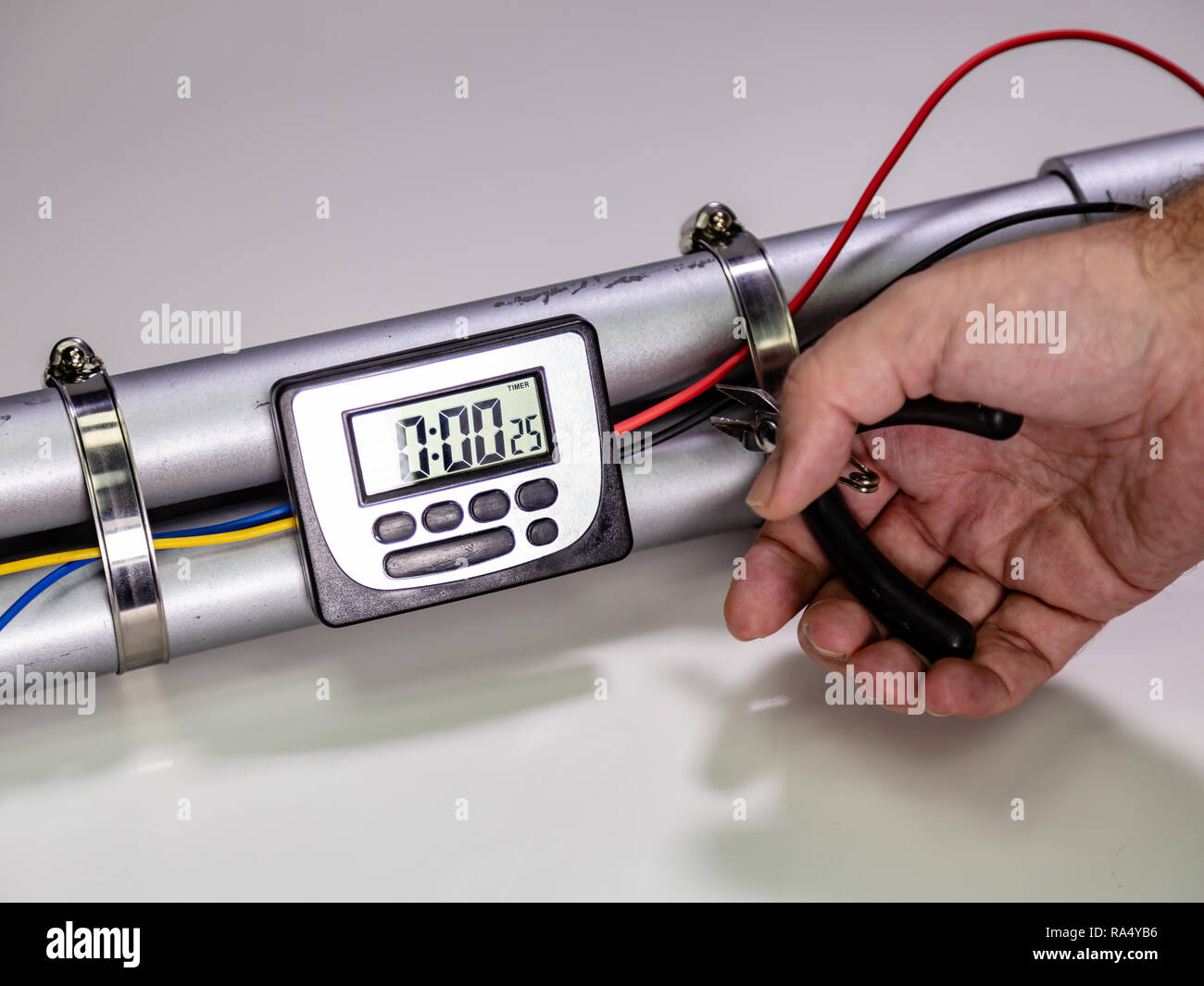 Hand cutting wire on pipe bomb with an lcd clock timer to trigger ...