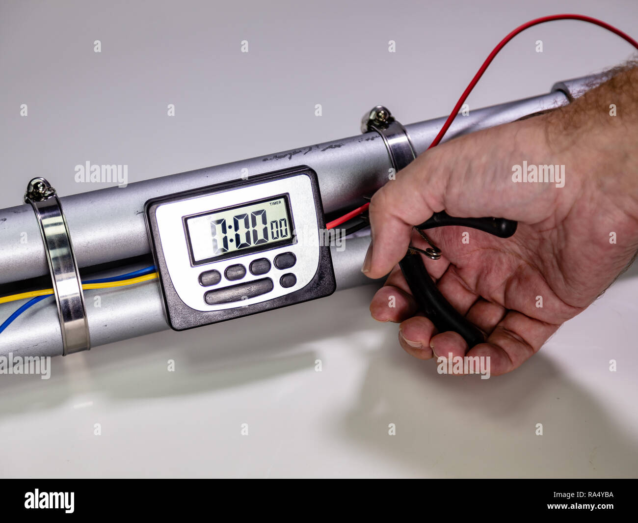 Hand cutting wire on pipe bomb with an lcd clock timer to trigger ...
