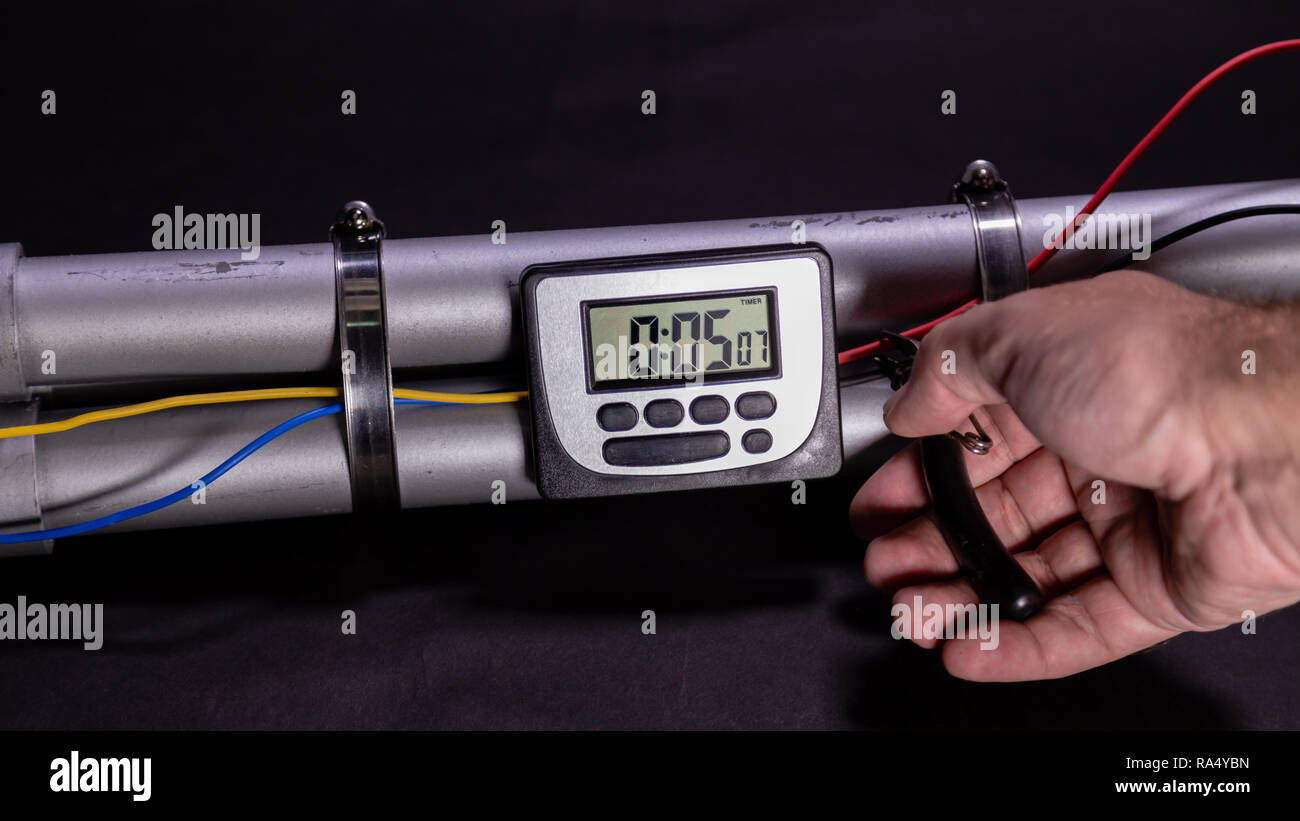 Hand cutting wire on pipe bomb with an lcd clock timer to trigger ...
