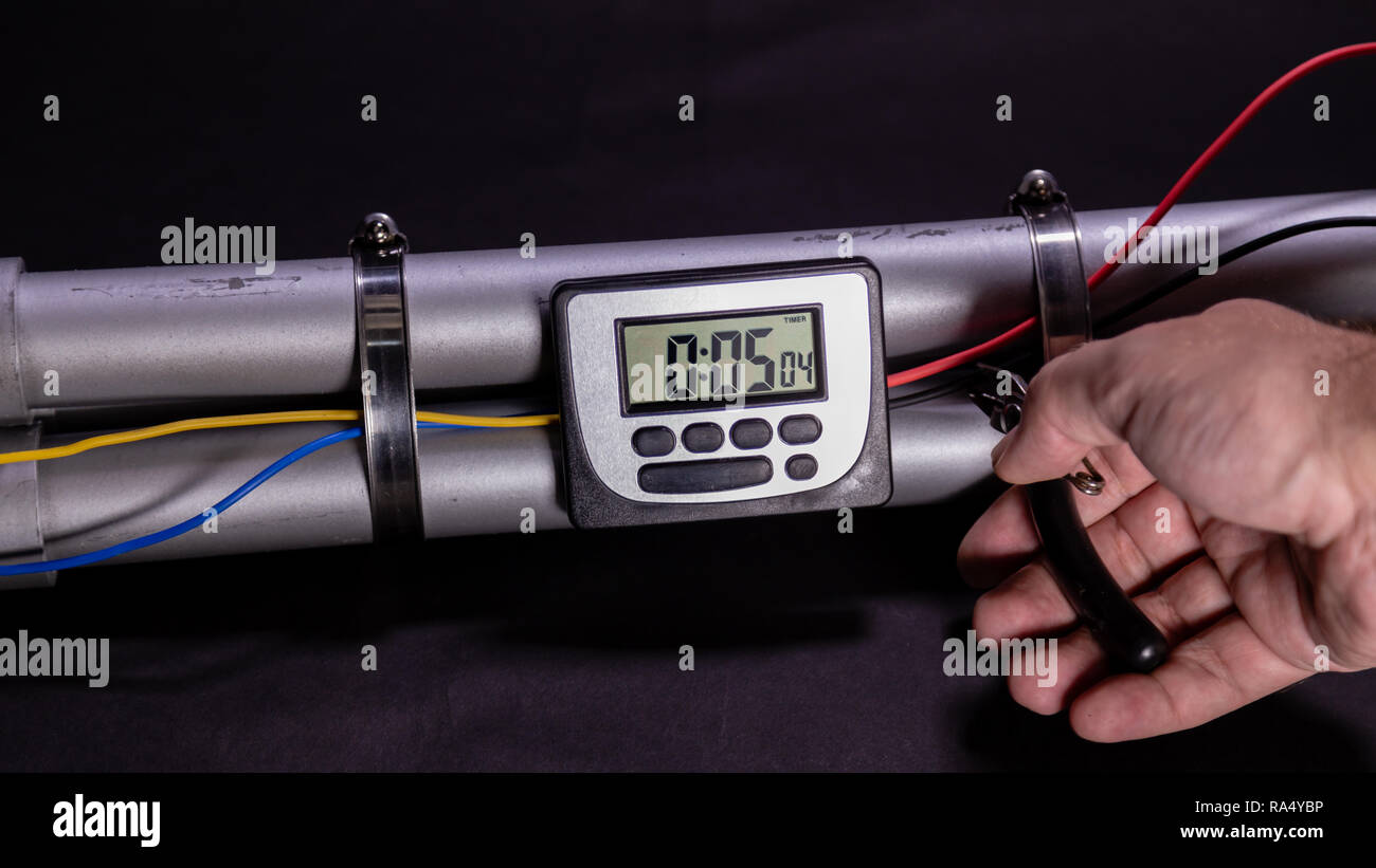 Hand cutting wire on pipe bomb with an lcd clock timer to trigger ...