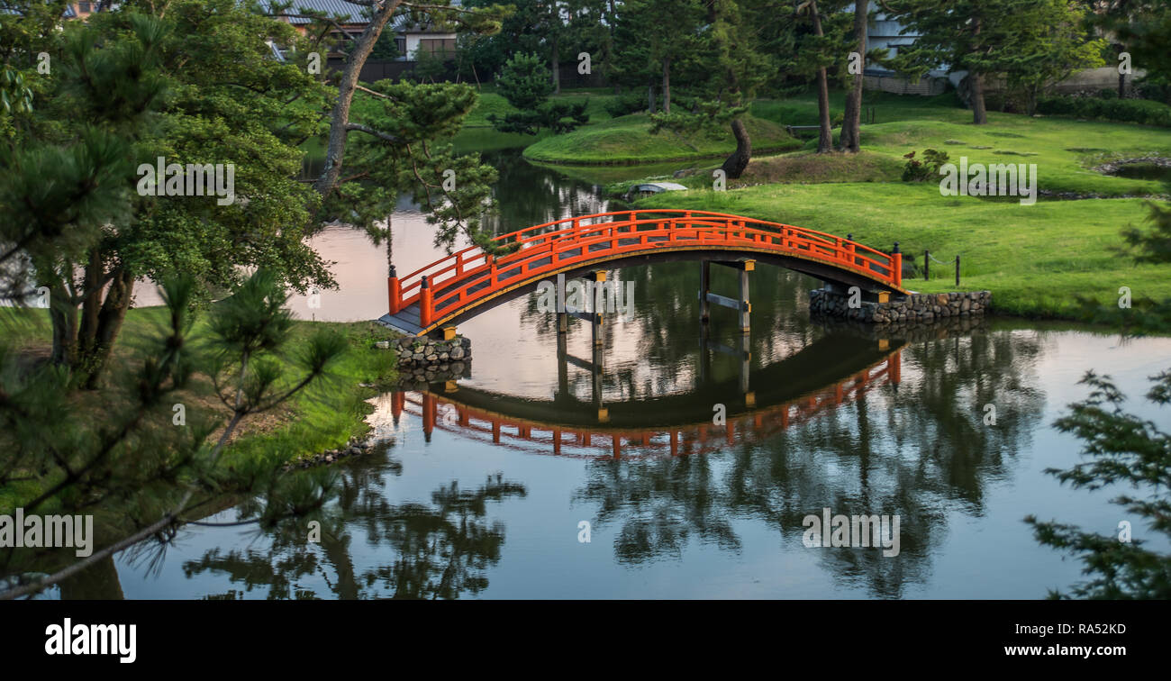 Orange curved bridge in beautiful japanese garden Stock Photo - Alamy