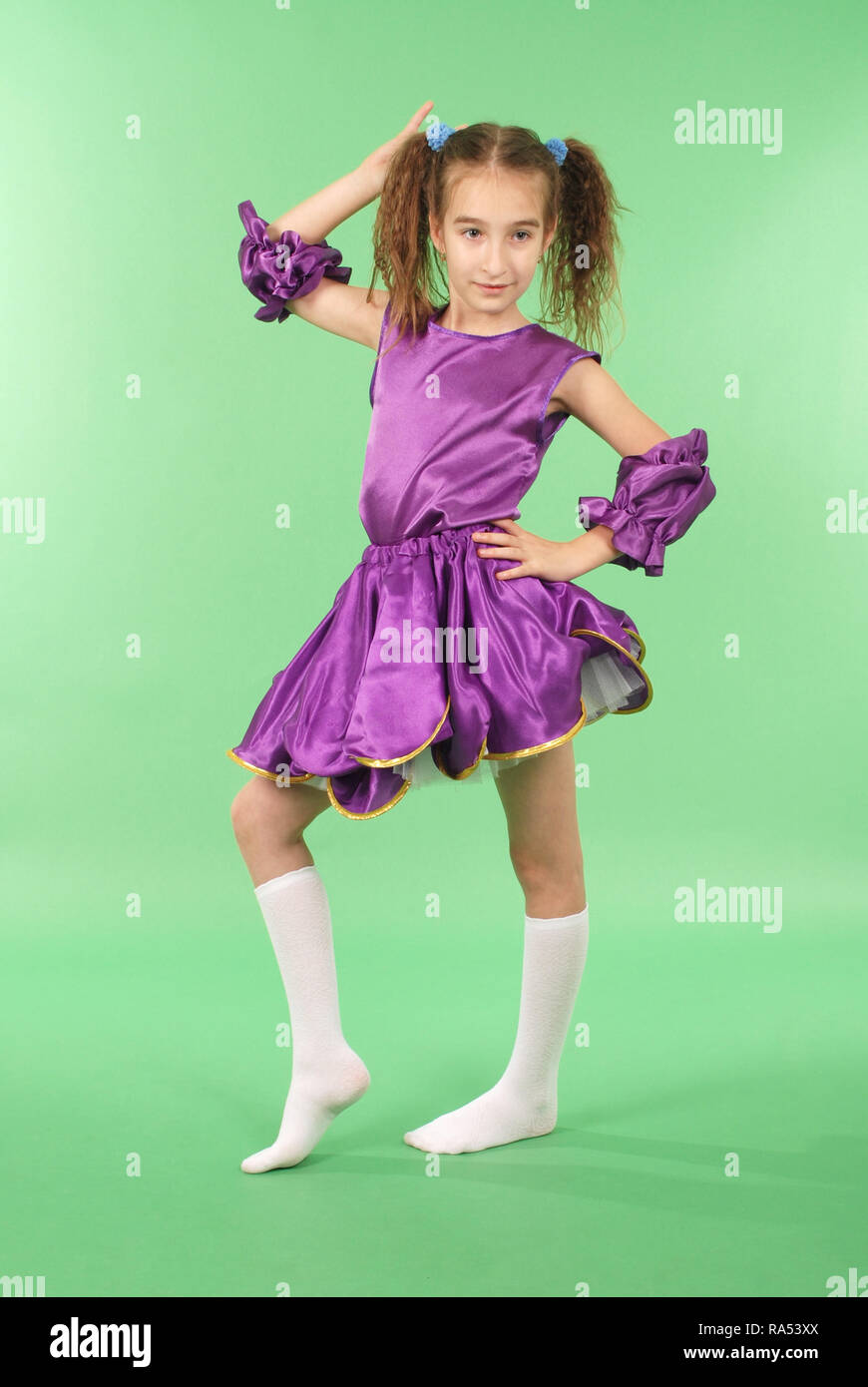 Pretty girl posing for the camera, in a violet short dress. Isolated on ...