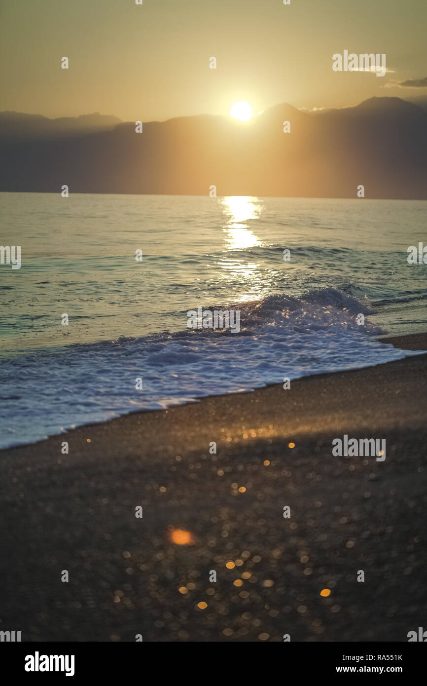 Golden splashing foamy sea waves at sunset sky and soft sun light ...