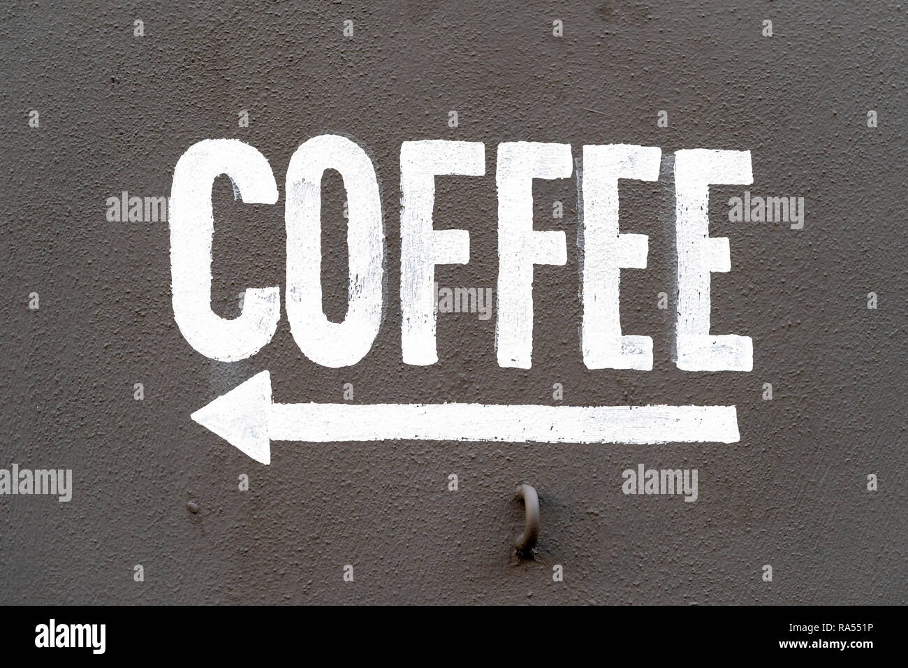 Coffee sign sign painted on a wall pointing toward a cafe Stock Photo ...