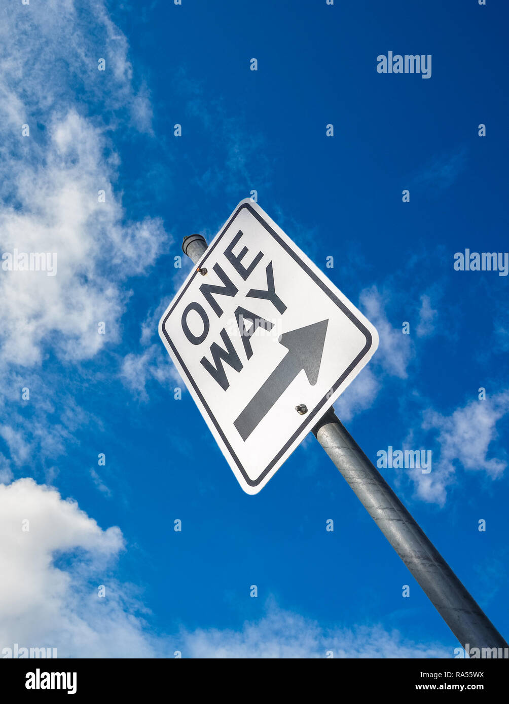 One way road sign on cloudy sky background Stock Photo - Alamy