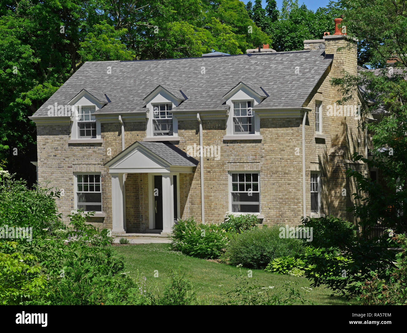 two story house surrounded by trees Stock Photo - Alamy
