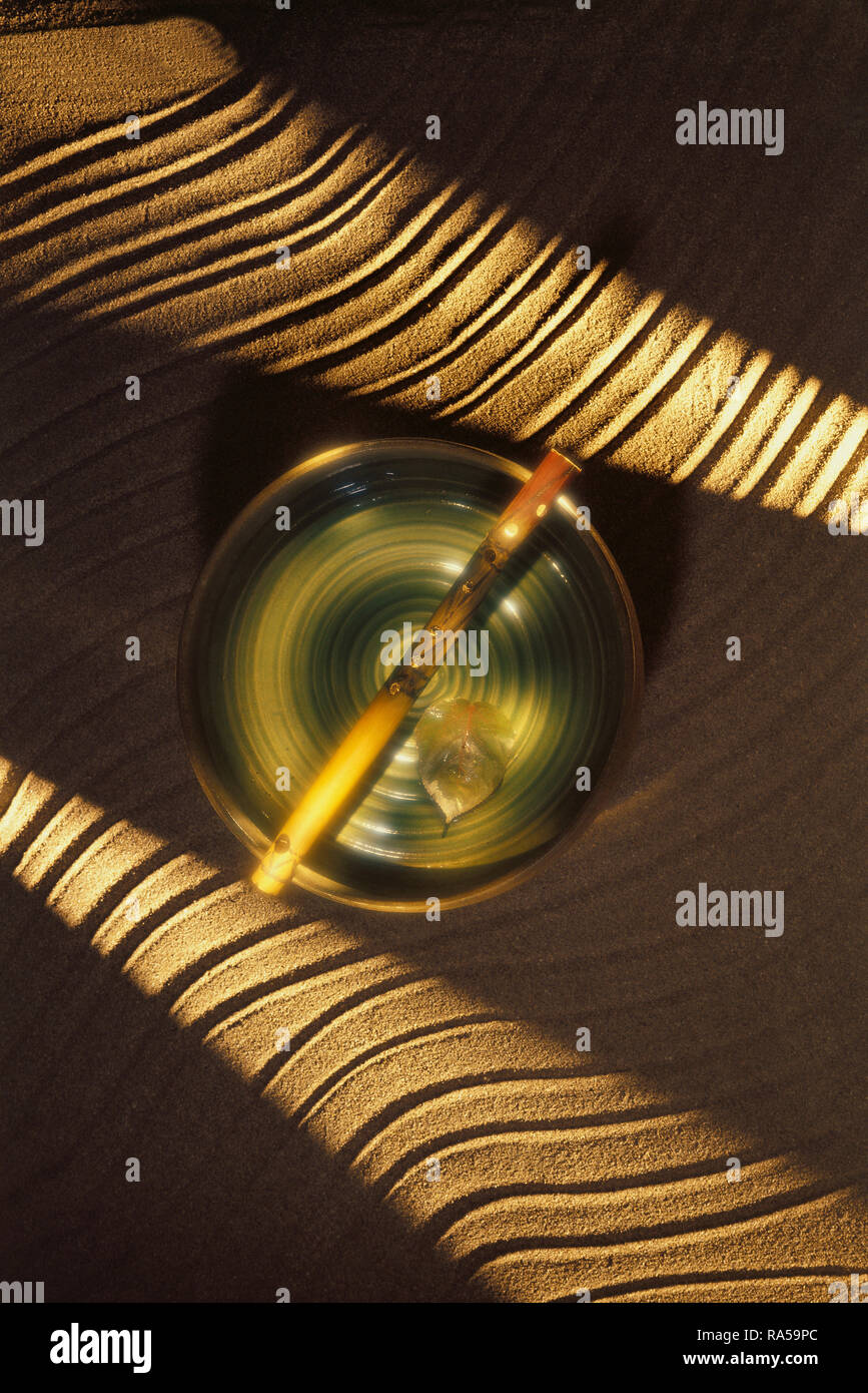 STILL LIFE OF A FLUTE ON A ROUND CERAMIC DISH FILLED WITH WATER, ON A ...