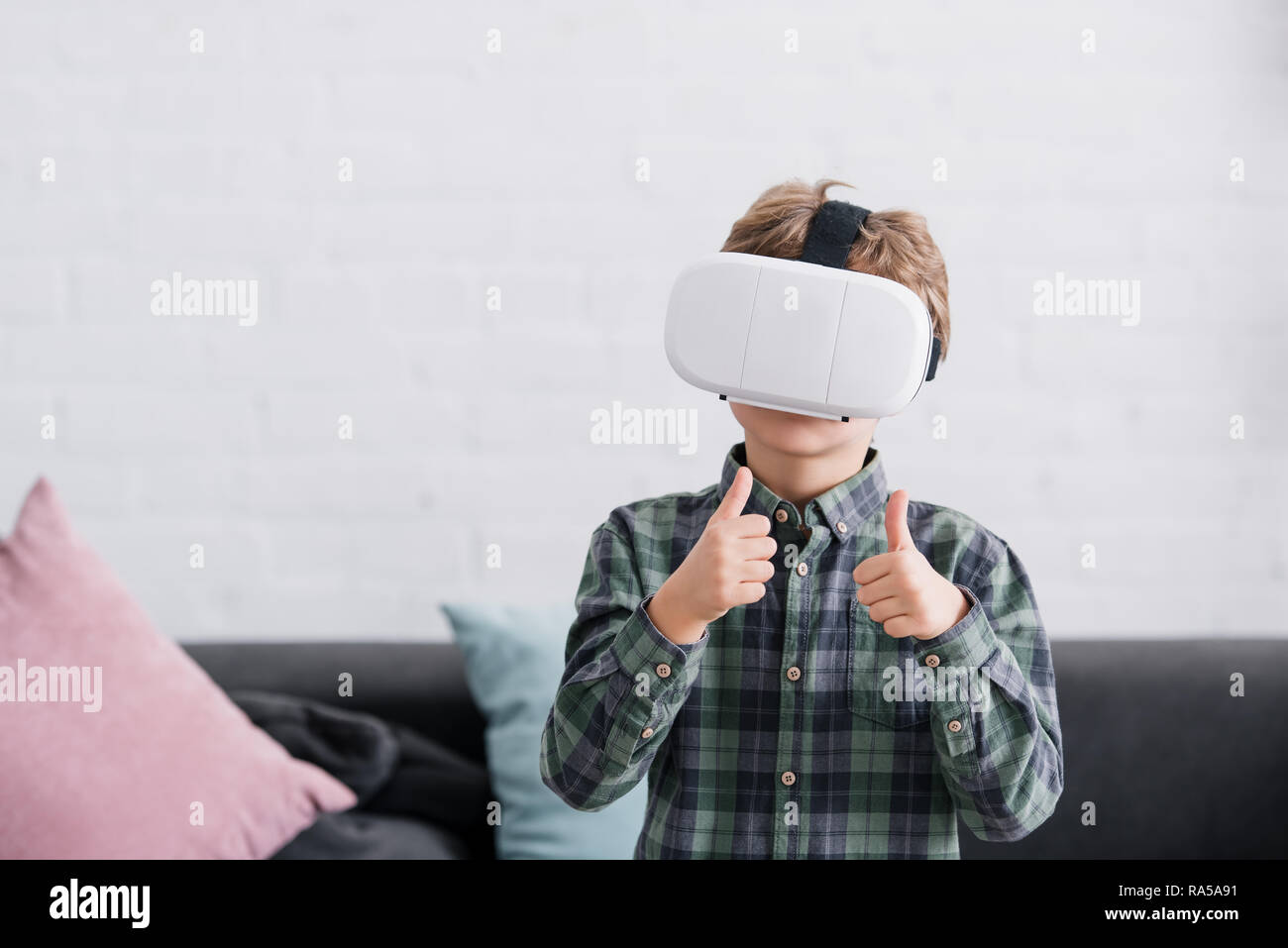 boy using virtual reality headset and showing thumbs up at home Stock ...