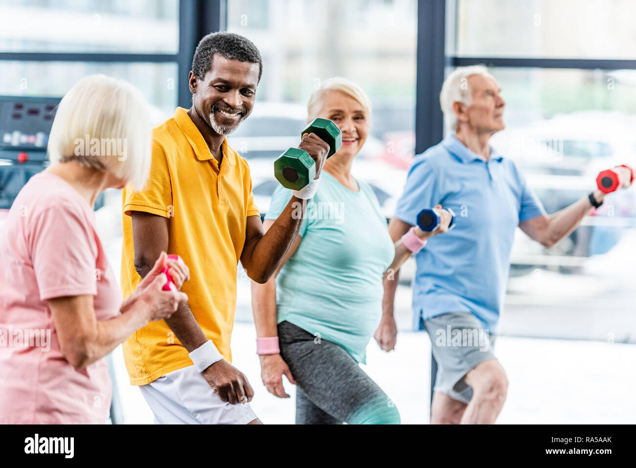 laughing african american man and his friends making exercise with ...