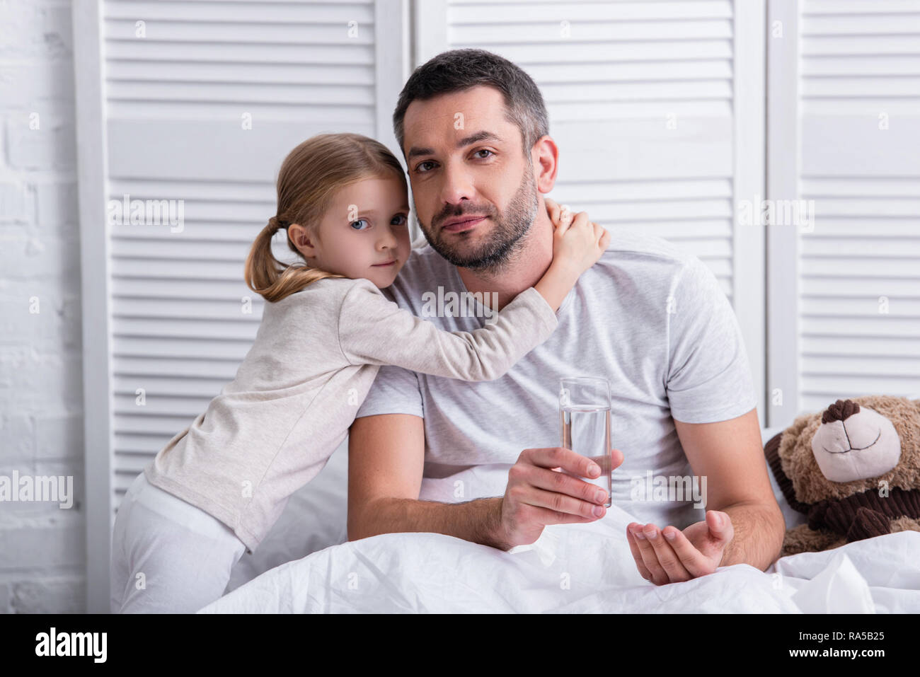 adorable daughter hugging sick father in bedroom Stock Photo - Alamy