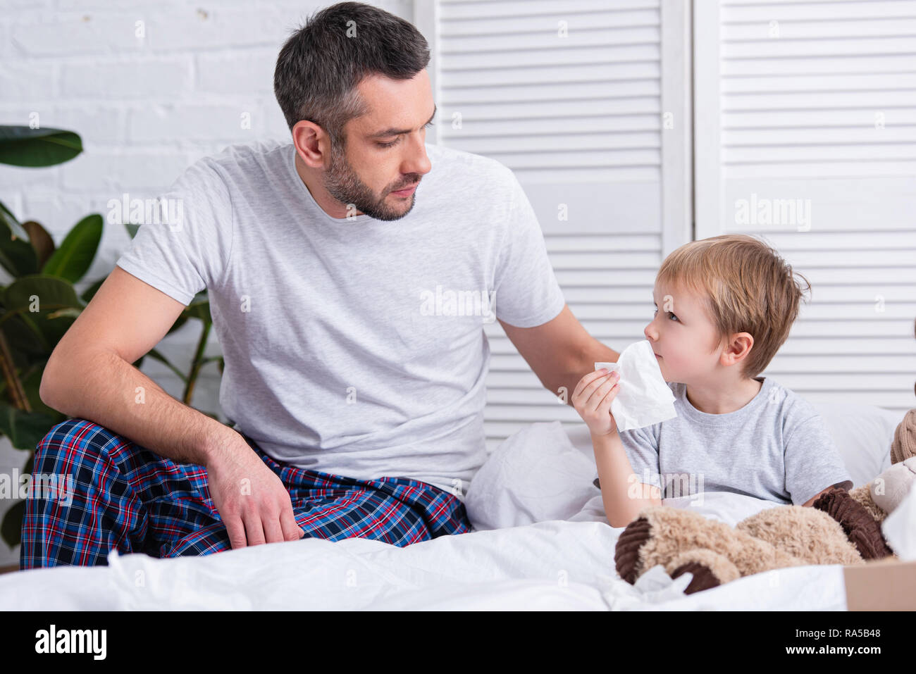 father taking care of sick son in bedroom Stock Photo - Alamy