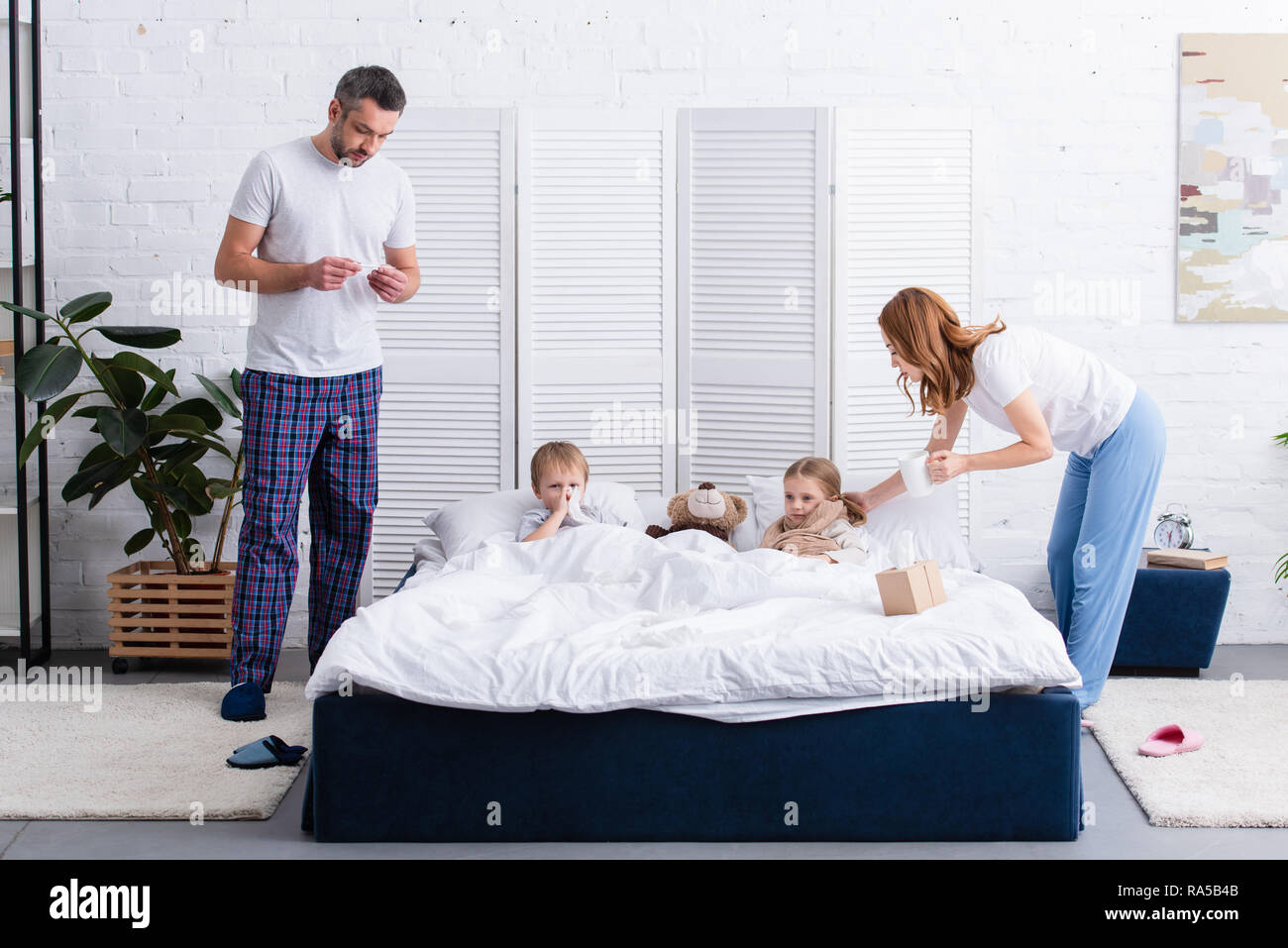 parents taking care of sick children in bedroom Stock Photo - Alamy