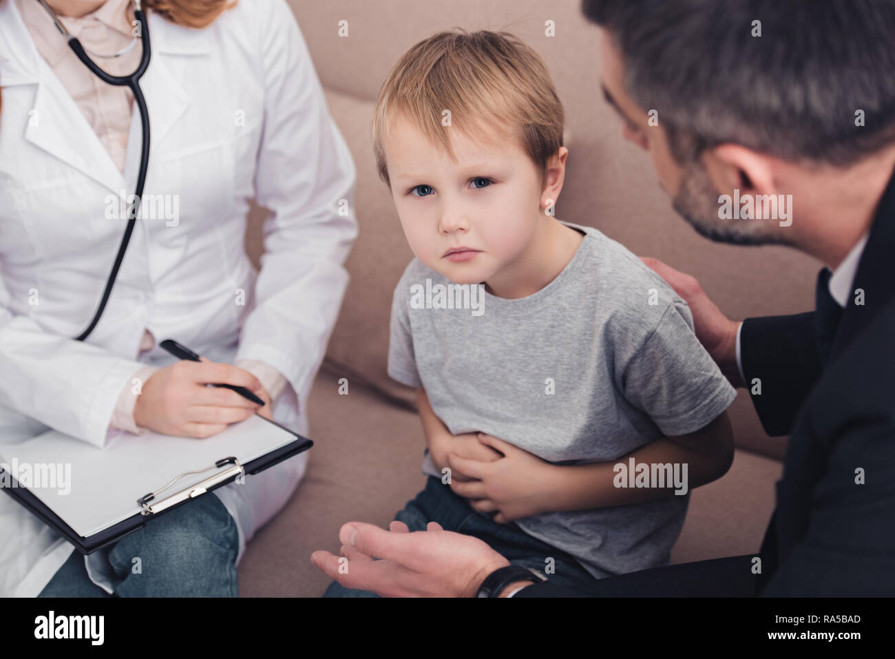 cropped image of pediatrist and man talking about sick boy in living ...
