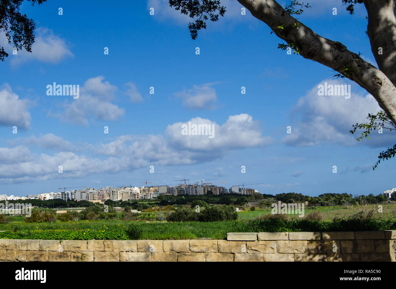 Malta landscape buildings in Qawra, with blue sky and white clouds and ...