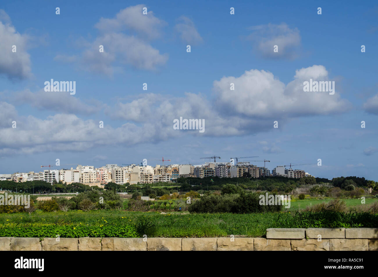 Malta landscape buildings in Qawra, with blue sky and white clouds and ...