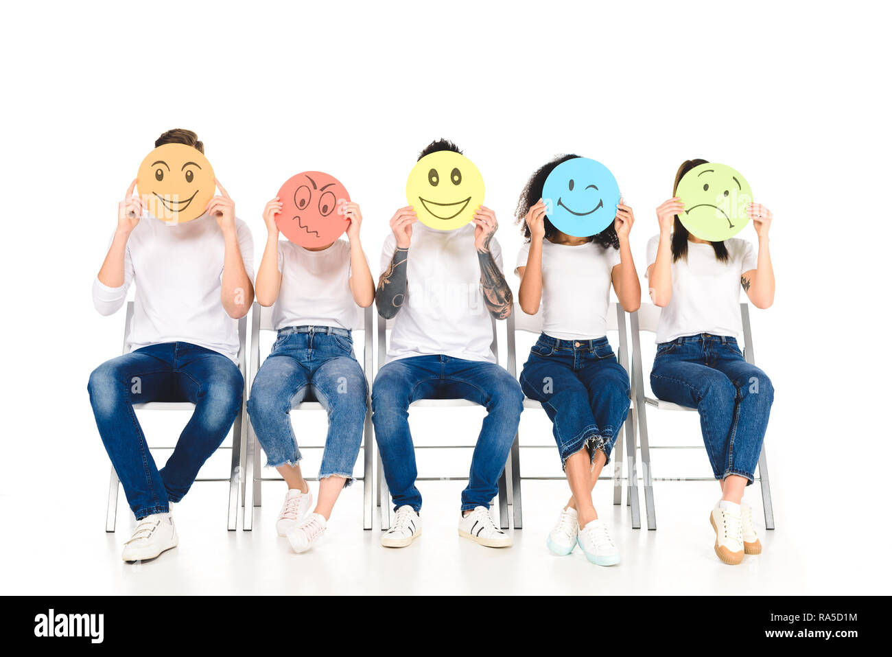 multicultural friends in blue jeans sitting on chairs isolated on white ...