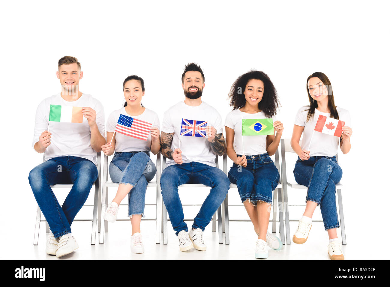 multicultural group of people sitting on chairs with flags of different ...