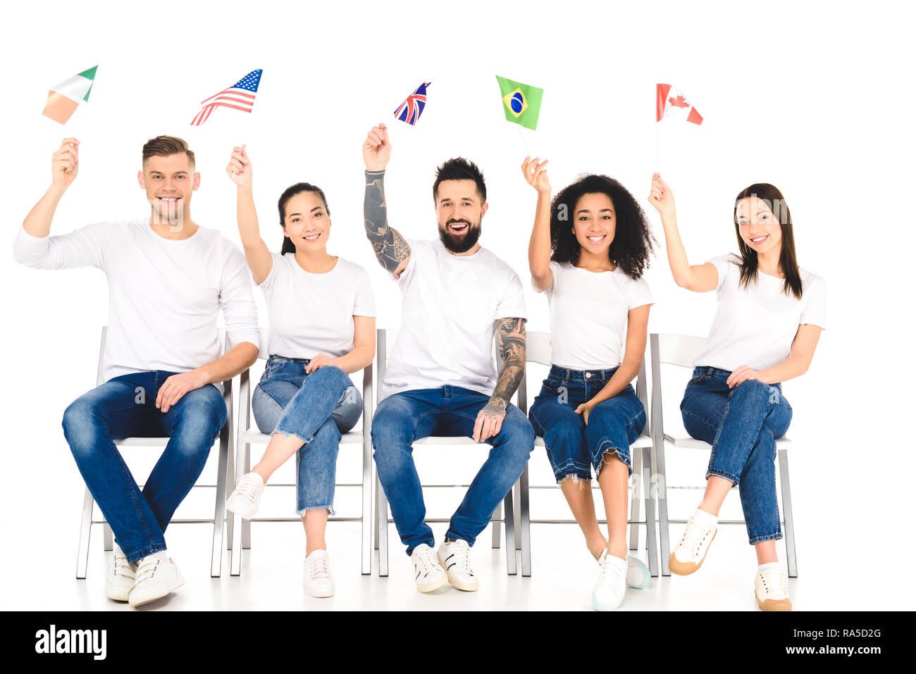 multicultural group of people sitting on chairs with flags of different ...