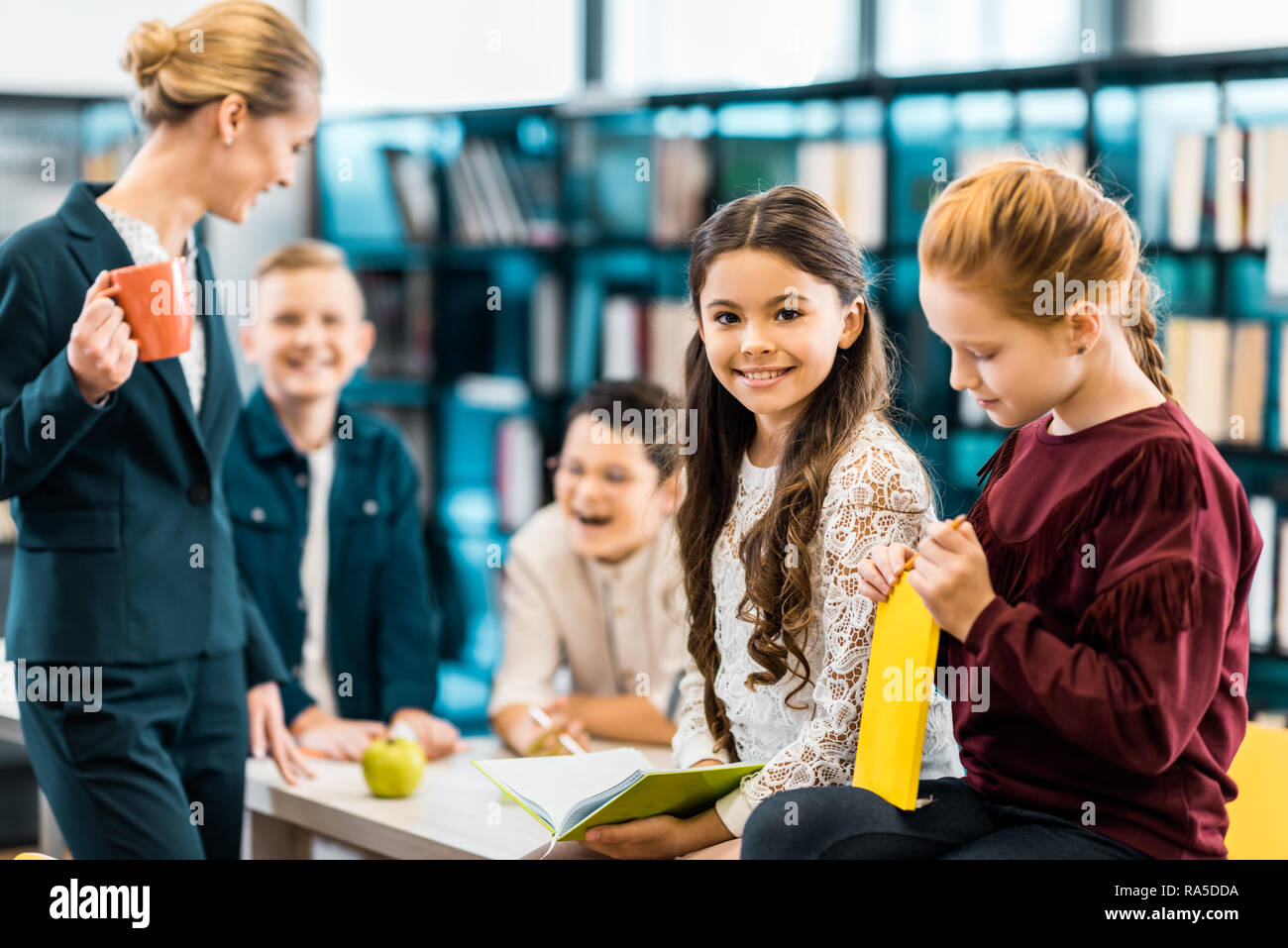 adorable happy schoolchildren reading books in library Stock Photo - Alamy