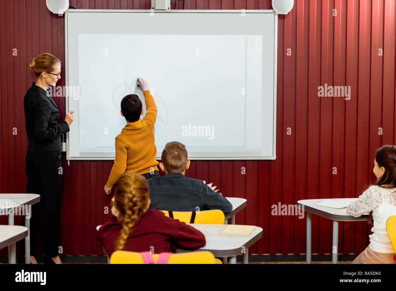 back view of boy writing on interactive whiteboard during lesson Stock ...