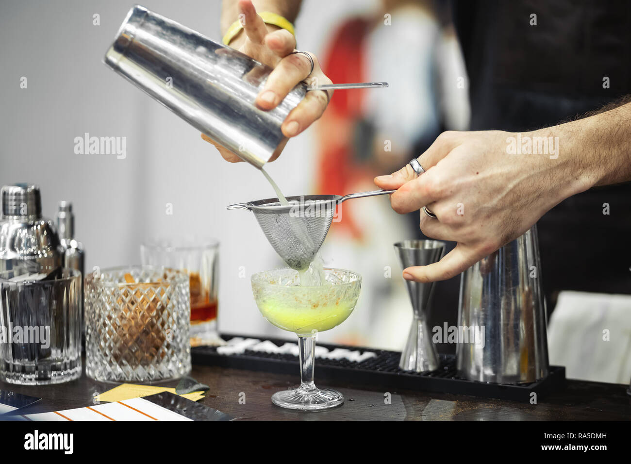 Strain through strainer. Barmen makes cocktail. Hands close-up. Strain ...