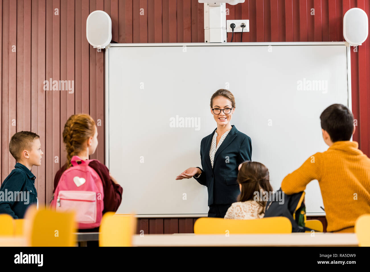 smiling young teacher making presentation to schoolchildren Stock Photo ...