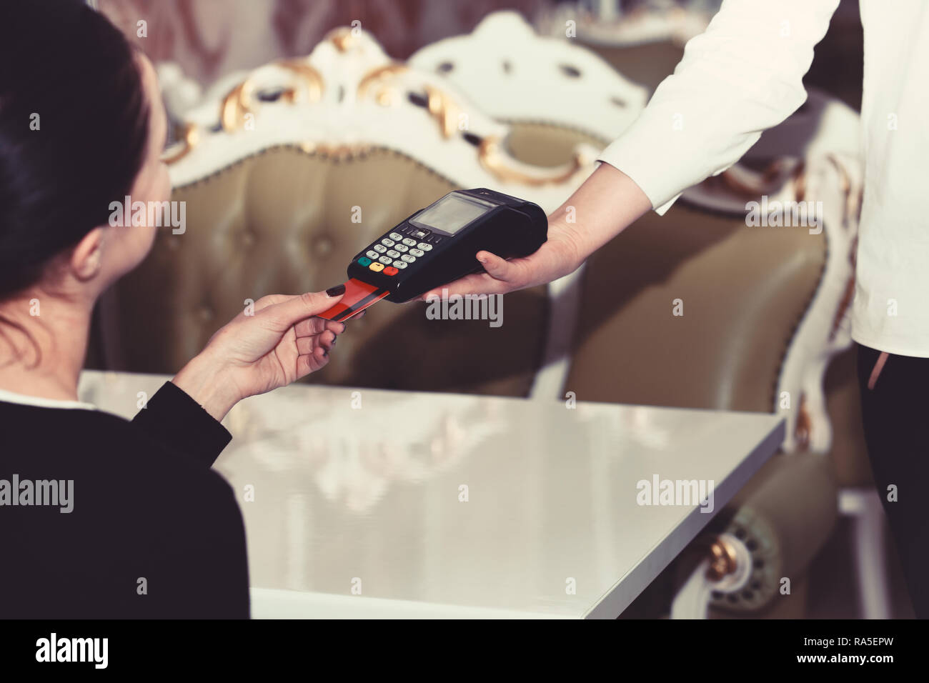 Credit card terminal for cashless payments. Cashiers hand holds credit ...