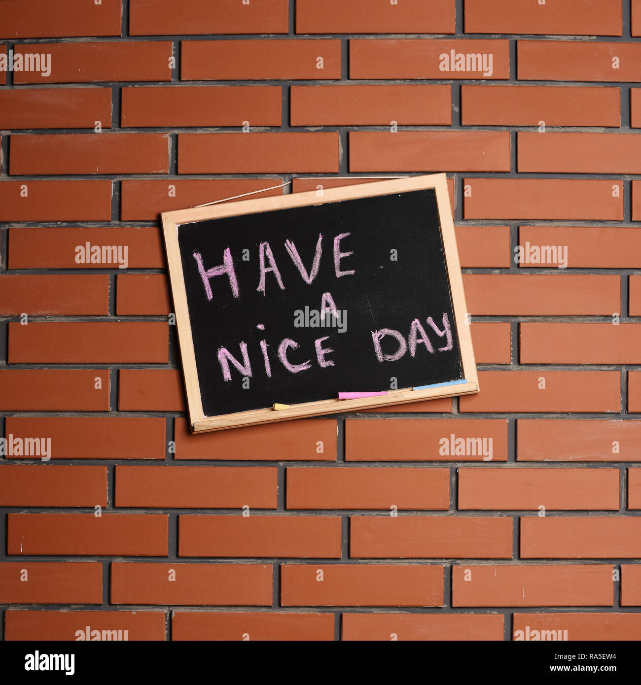 textured brick wall background and blackboard with positive text in ...