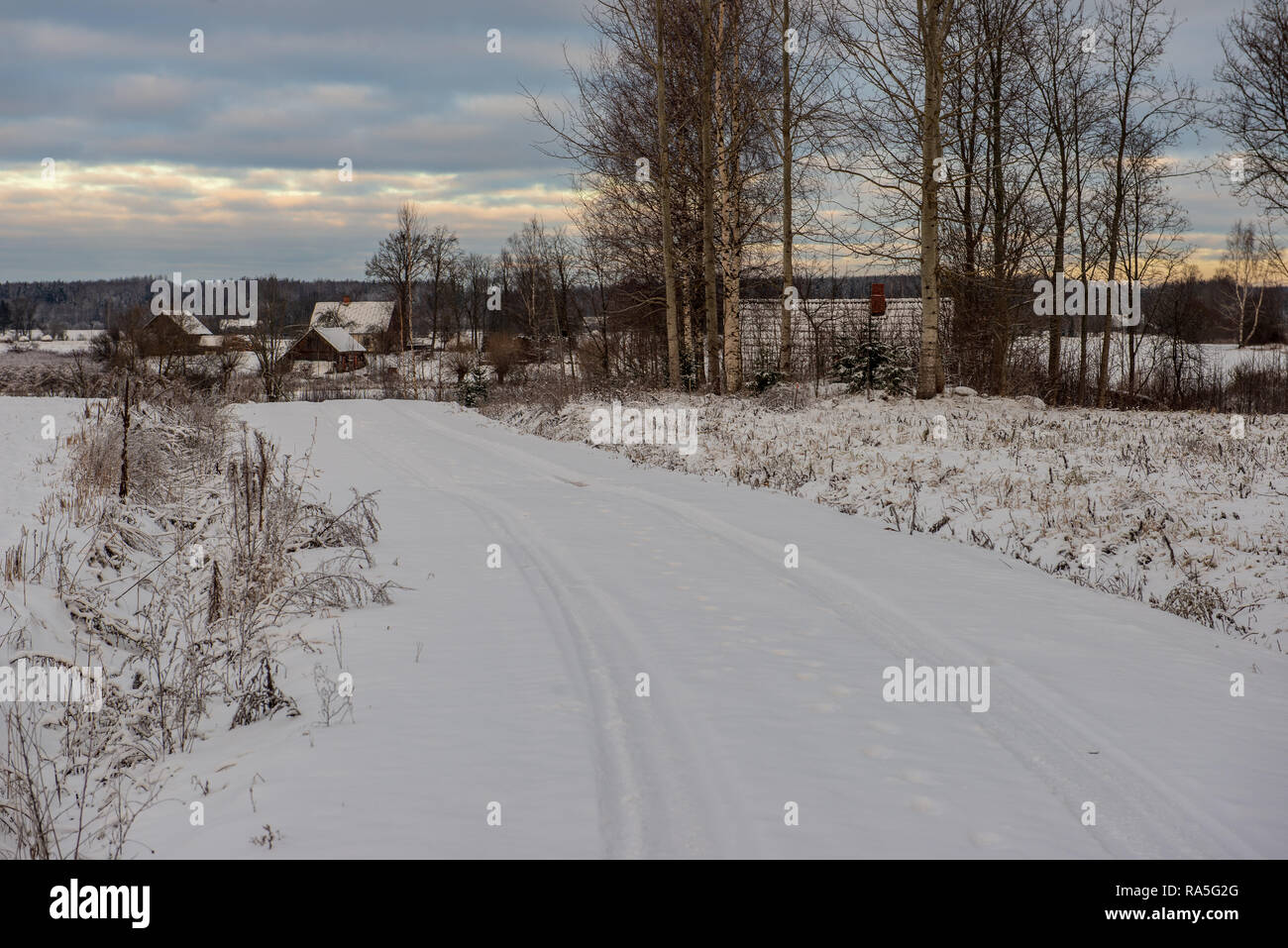 snow covered winter road with tire tracks in perspective with blue sky ...