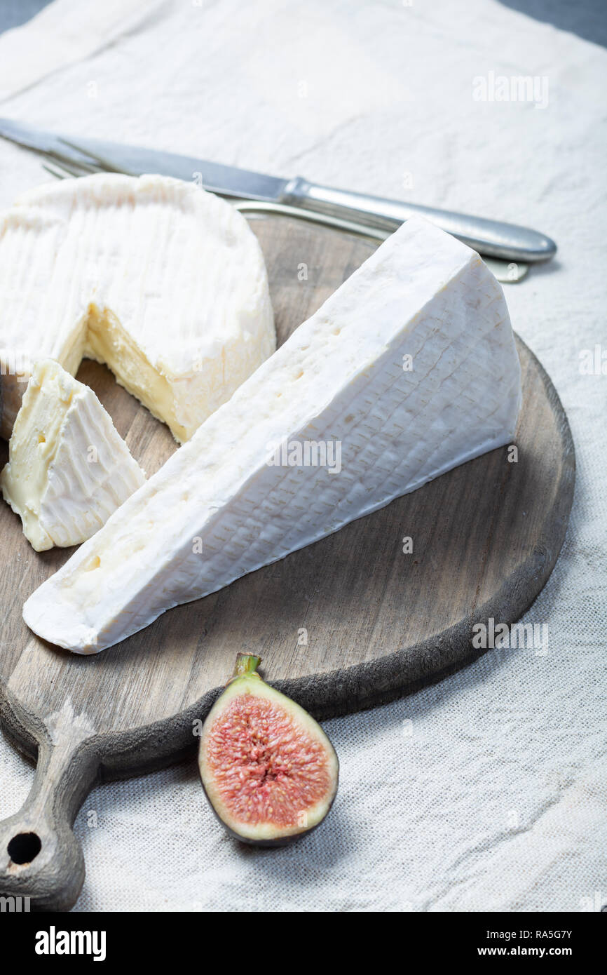Two pieces of French soft cheeses Brie and Camembert with white mold ...
