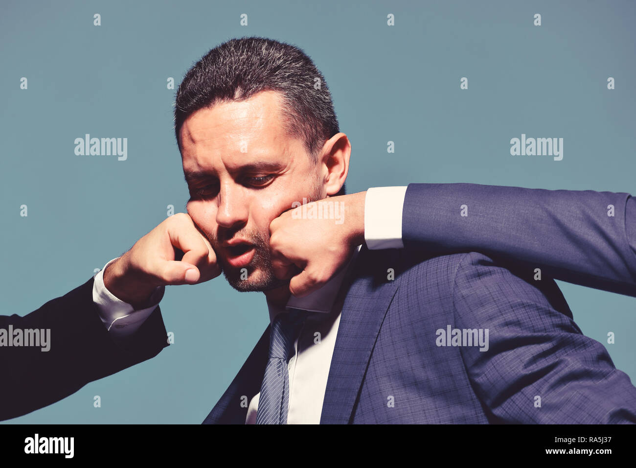 Businessman with confused face in formal suit on blue background ...