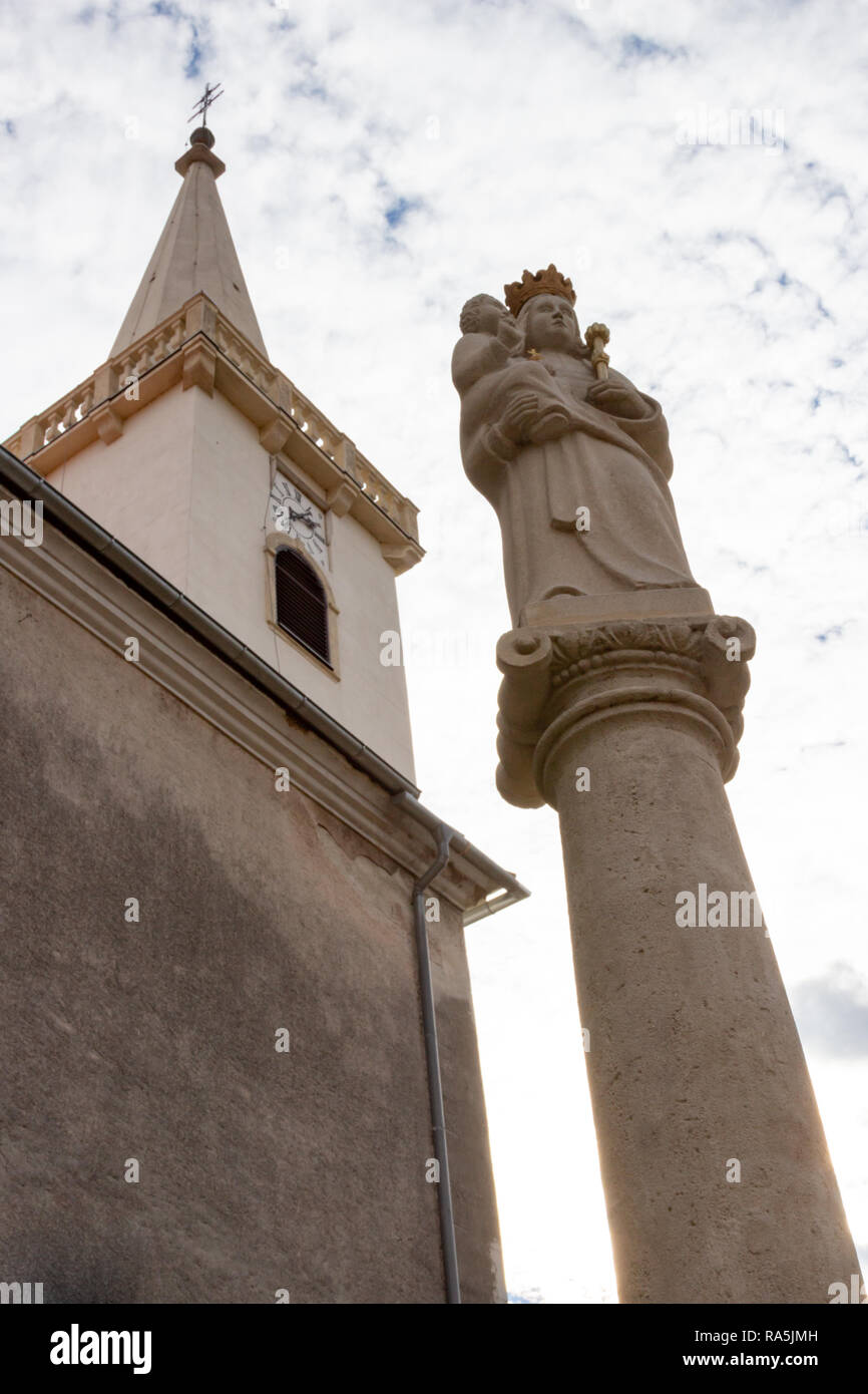 The steeple of the Catholic church and the Heaven`s Queen Woman column ...