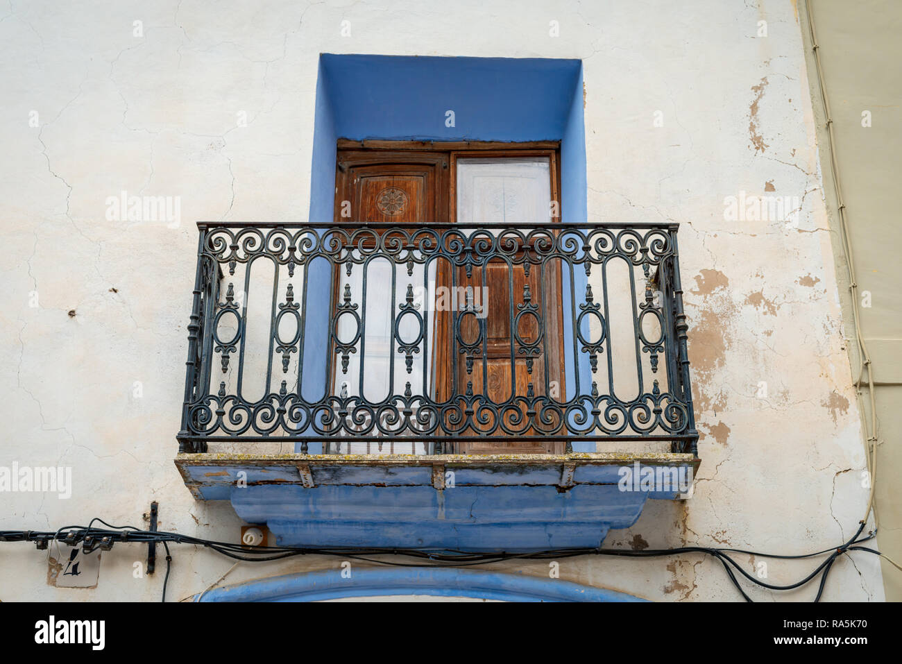 A rustic light blue painted apartment balcony on the exterior of a home ...