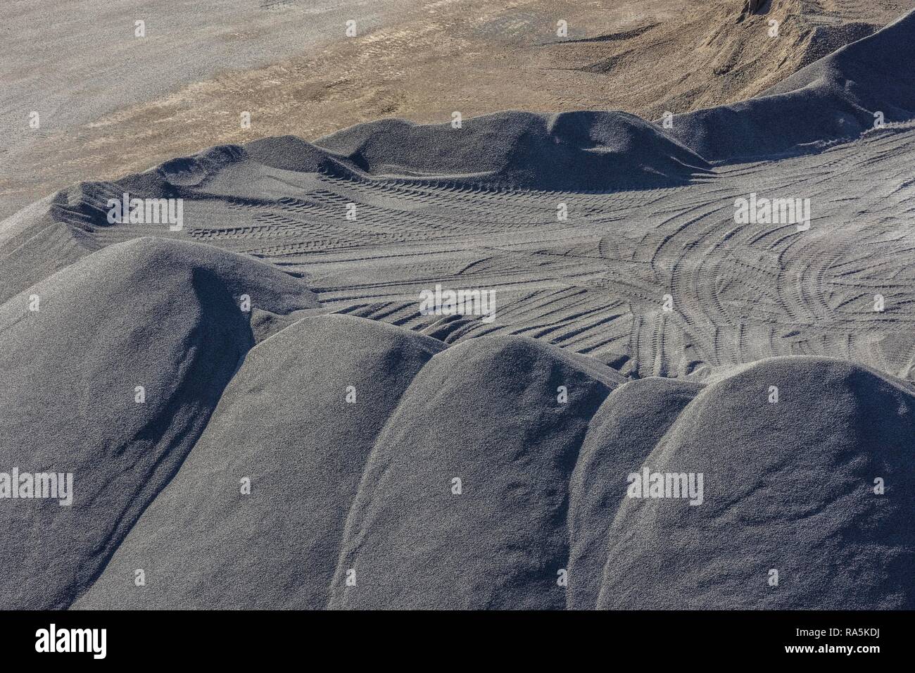 Sand heaps and excavator tracks in the basalt quarry, observation tower ...