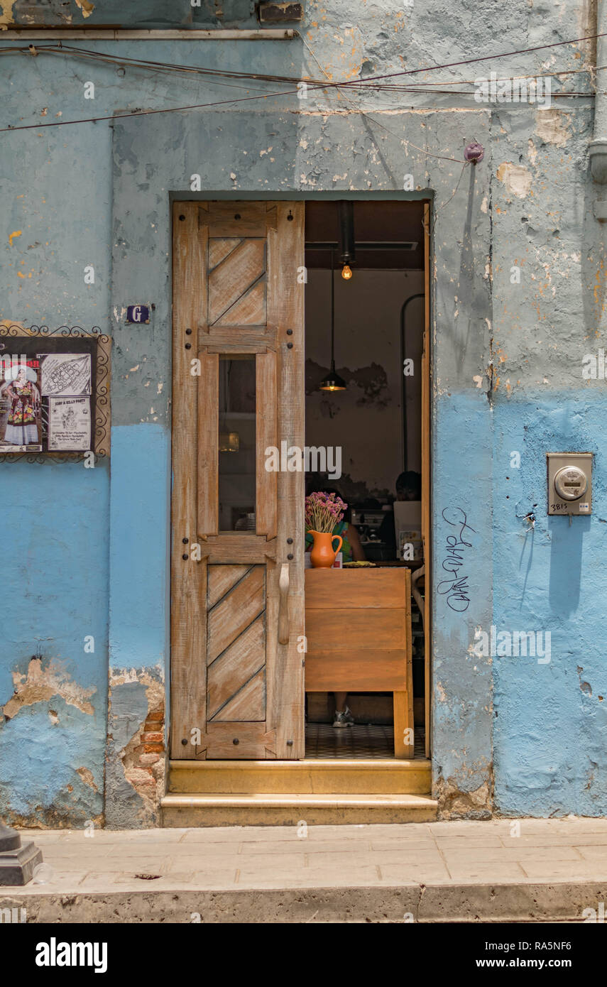 Cafe storefront, with blue and grey grungy wall and aged double wooden ...