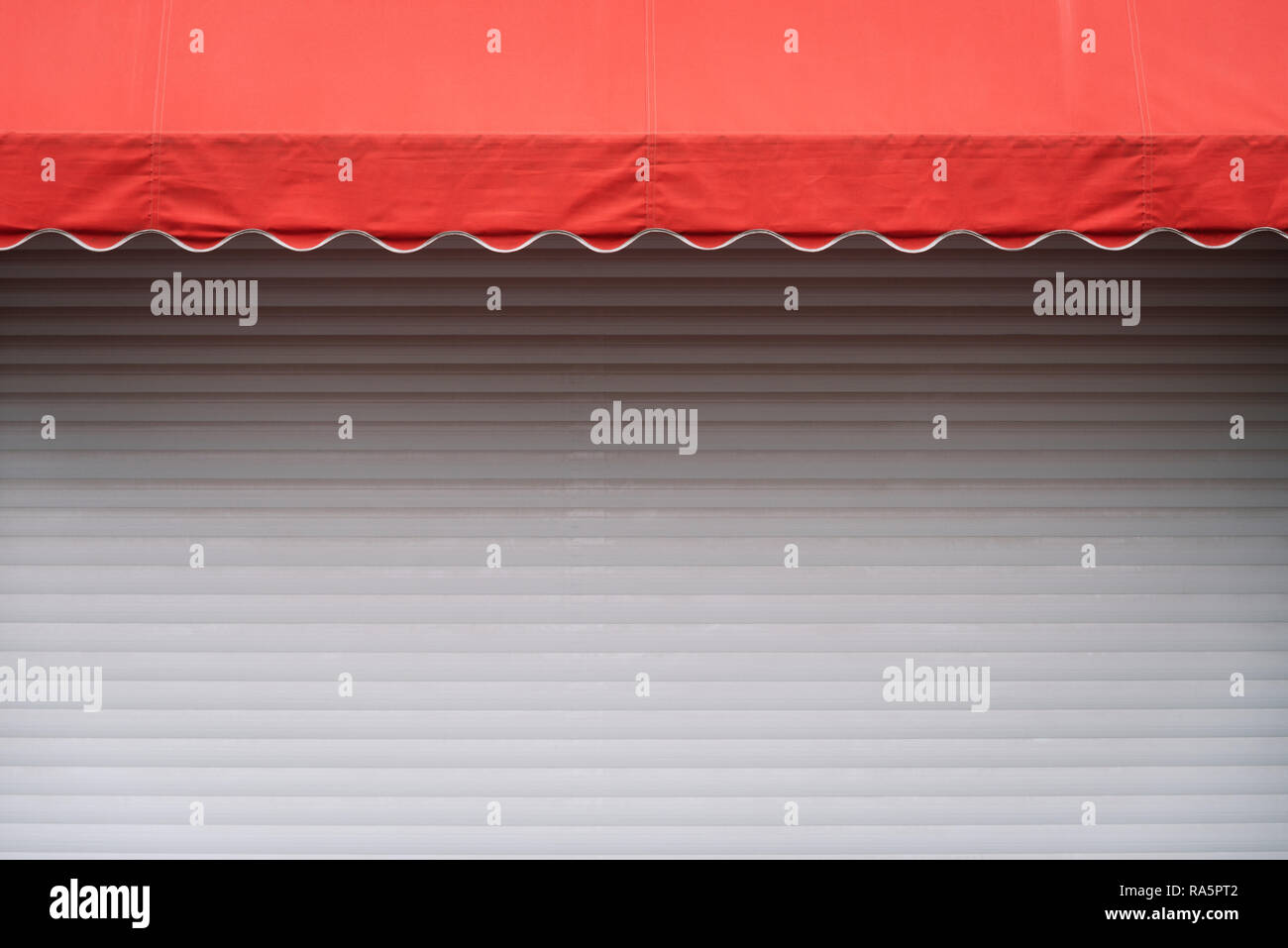 White stall with closed shutters and red sunshade. Geometric contrast ...