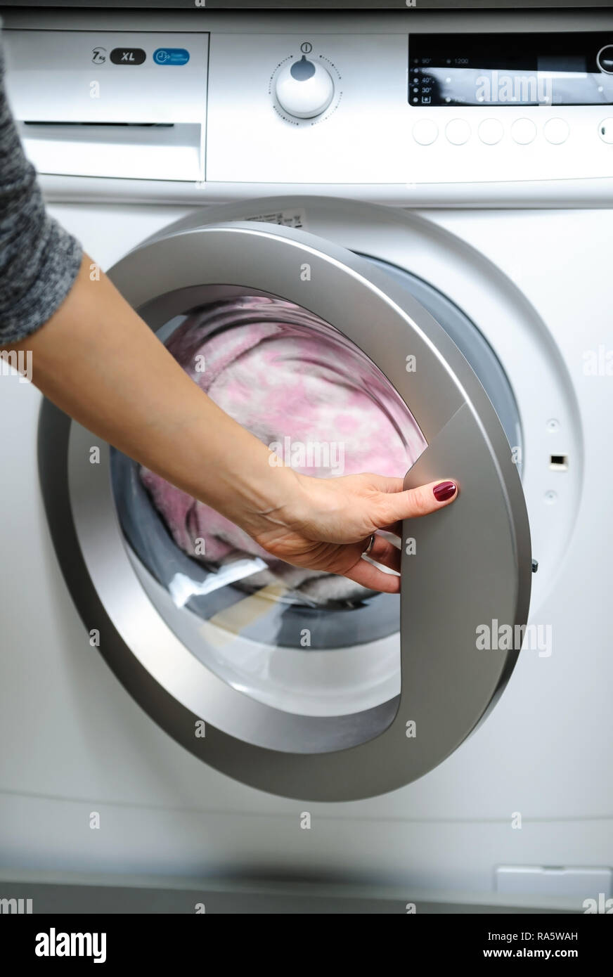 Female hand open the door of the washing machine Stock Photo - Alamy