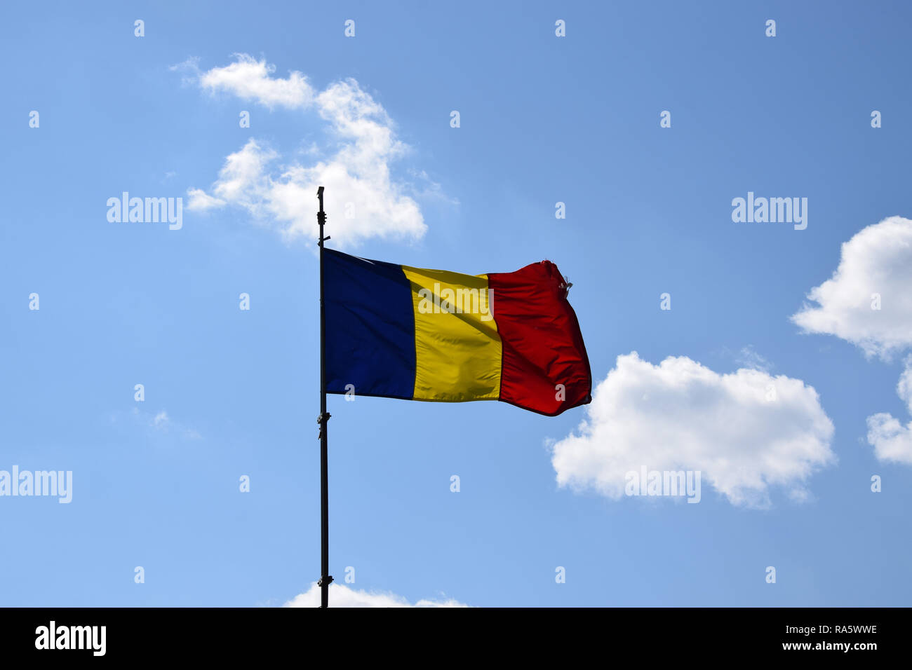 Romanian flag waving in the wind in front of a clean blue sky. Romania ...