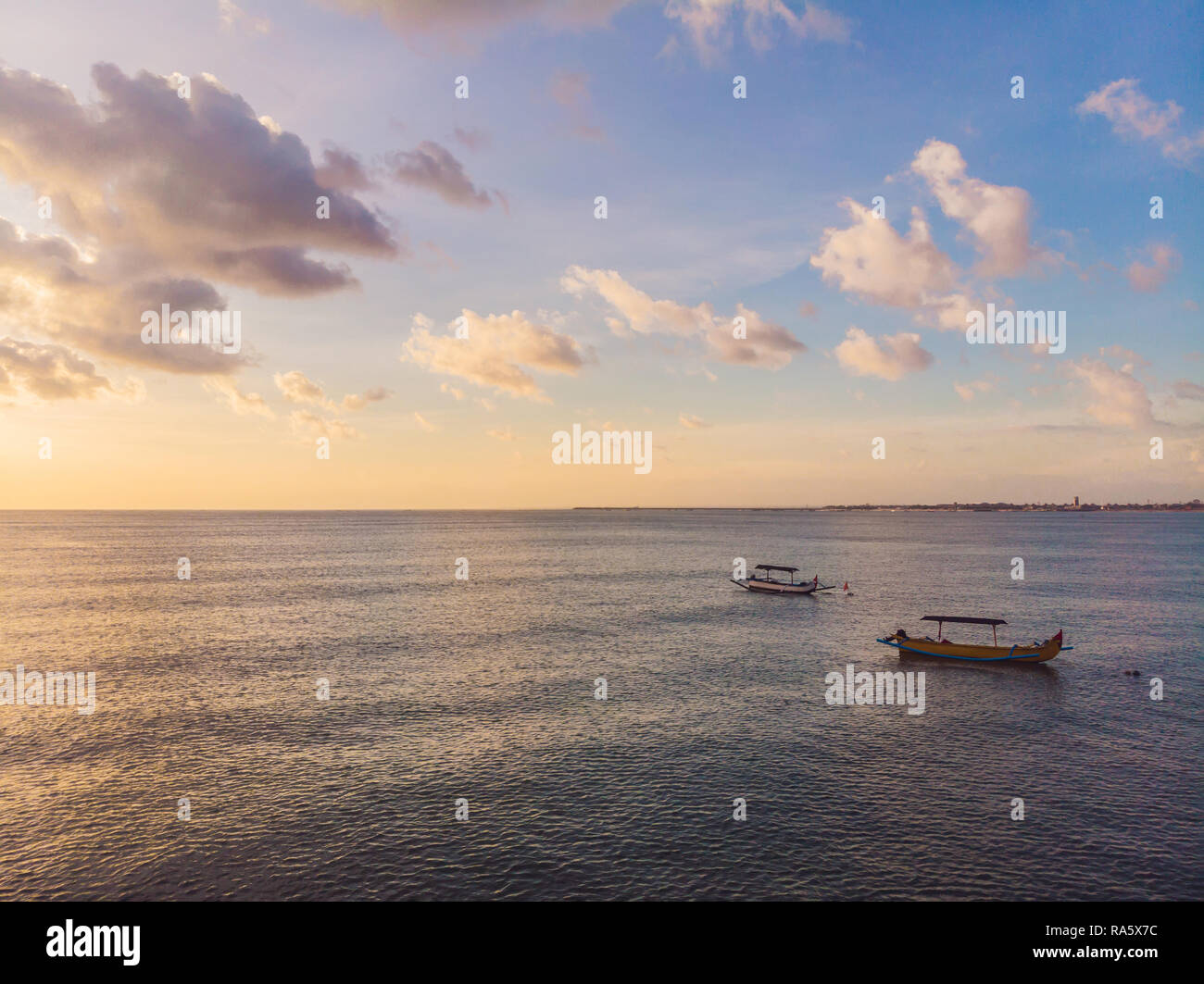 Traditional Balinese boat Jukung at Jimbaran beach at sunset in Bali ...