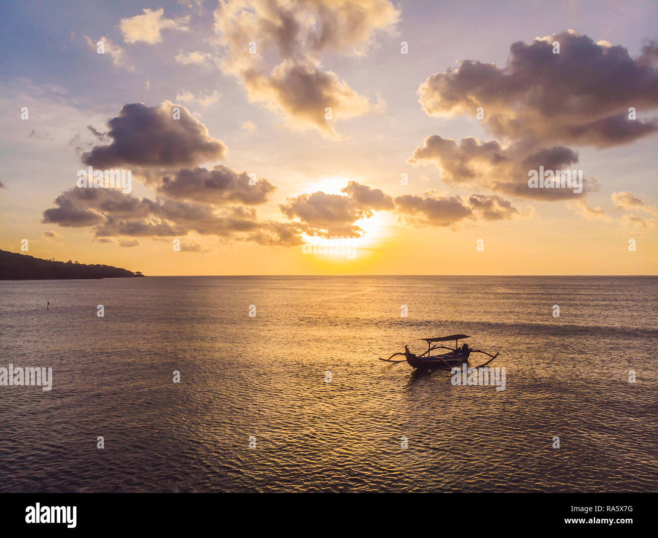 Traditional Balinese boat Jukung at Jimbaran beach at sunset in Bali ...