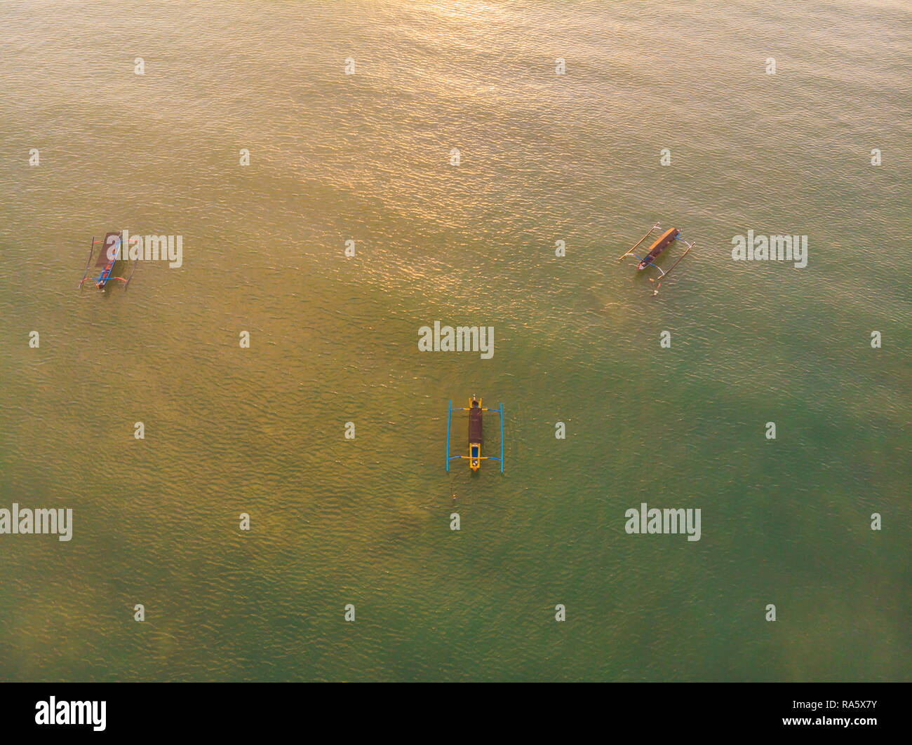 Traditional Balinese boat Jukung at Jimbaran beach at sunset in Bali ...