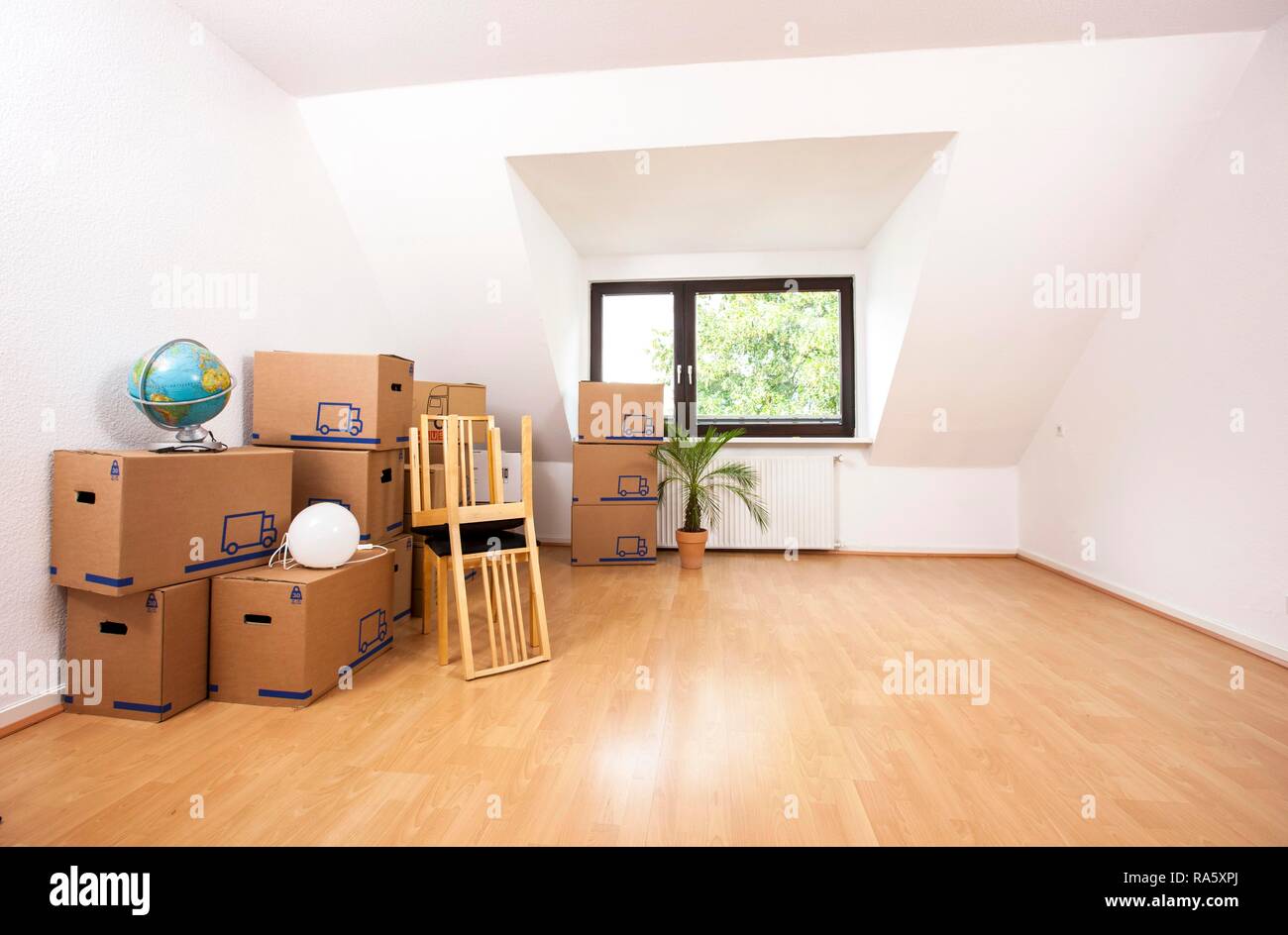 Moving boxes and some furnishings in an empty room of a loft apartment ...