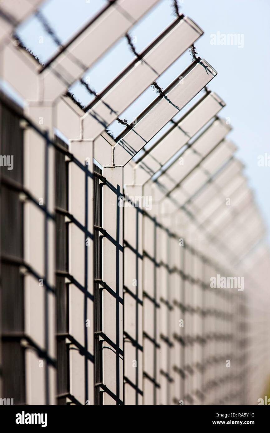 Security fence with barbed wire on top Stock Photo - Alamy