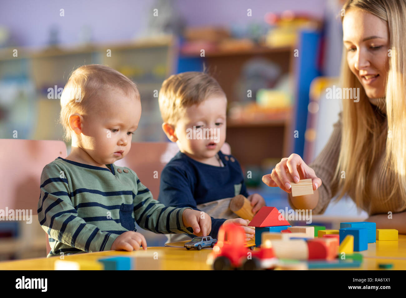 Nursery children playing with teacher in the class room Stock Photo - Alamy