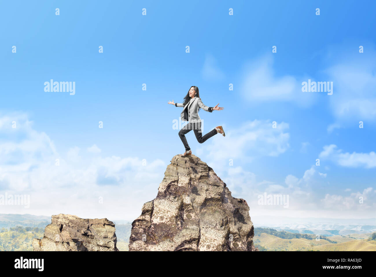Happy asian business woman jumping on top of the mountain. Successful ...