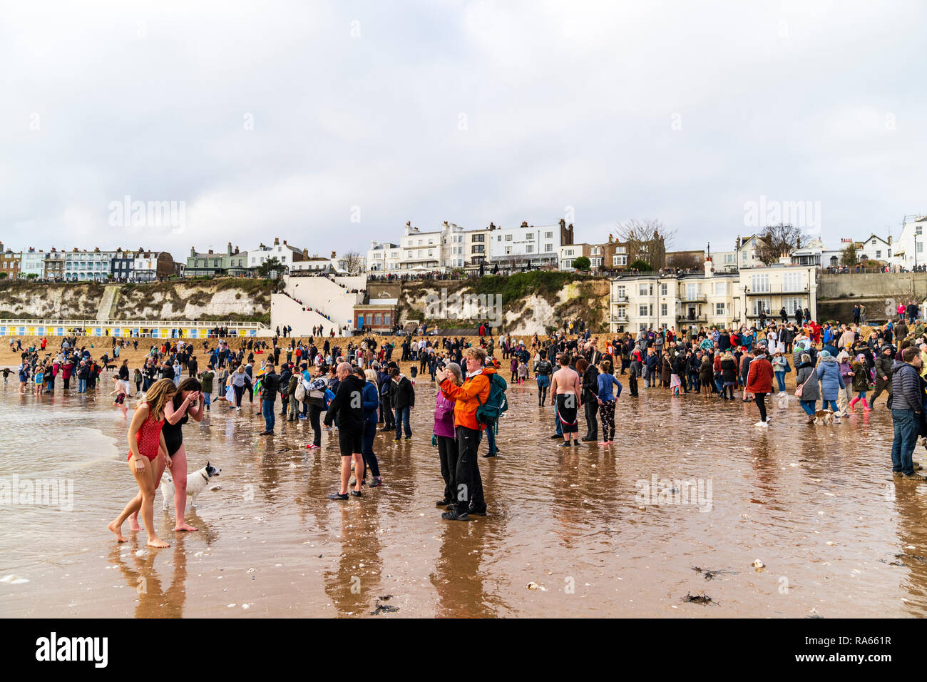 People in swim wear, wading back to the beach from the sea after the ...