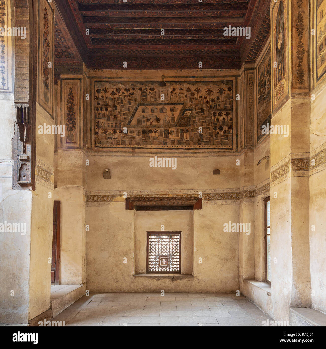 Stone wall with wooden window (Mashrabiya) and mural depicting city of ...
