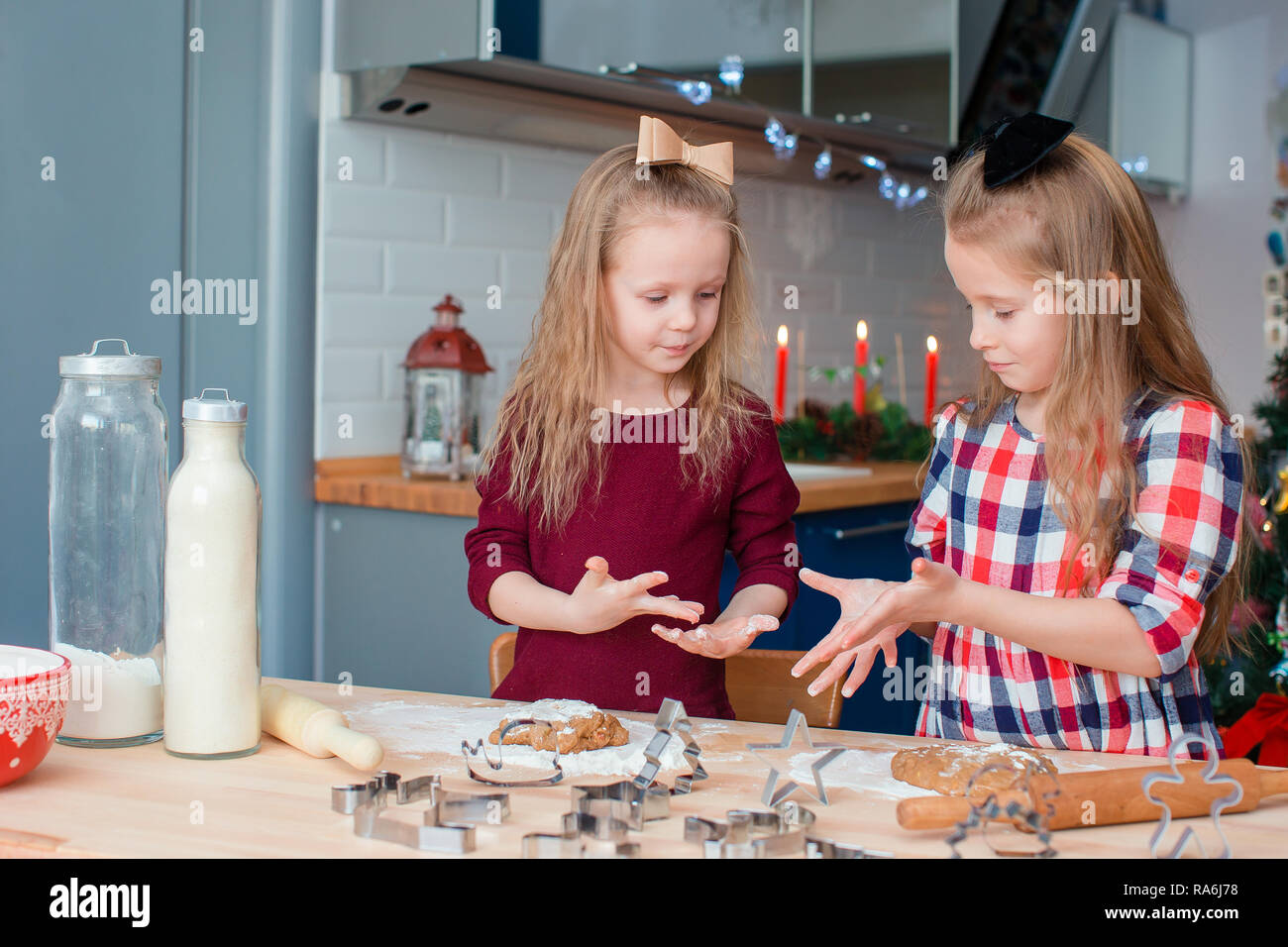 Little happy girls baking gingerbread cookies for Christmas at home ...