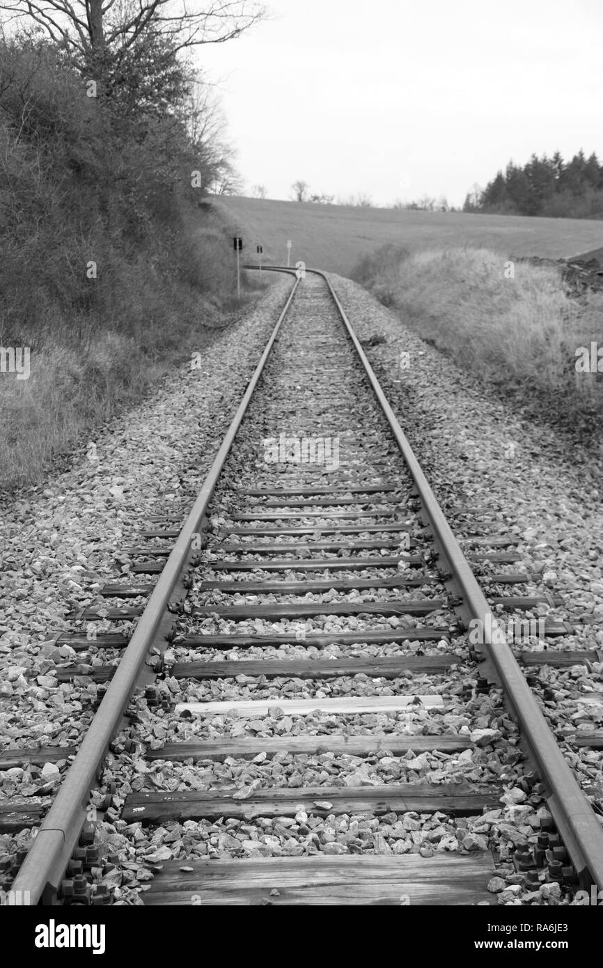 Railway tracks run away from the viewer in a curve Stock Photo - Alamy